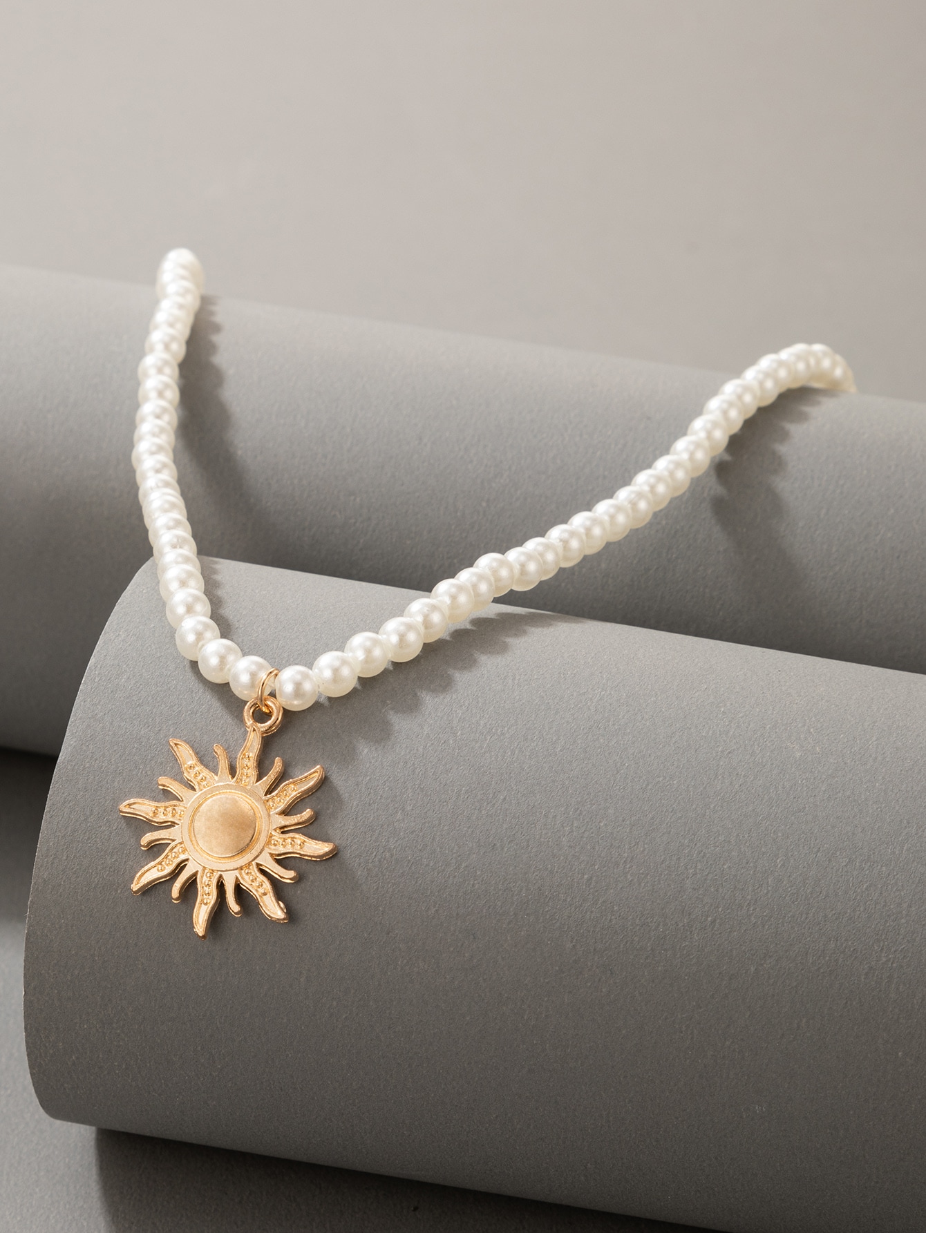 Collier perlé à pendentif soleil