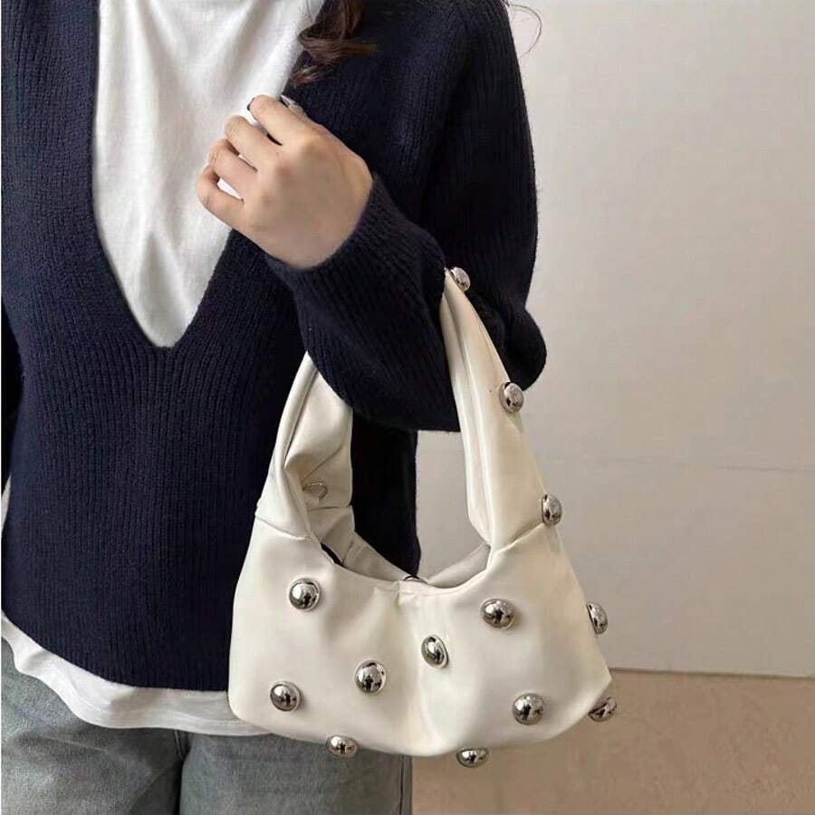 The Rivet Woman Is Carrying A Crescent Moon Woman Bag Diagonally On One ...